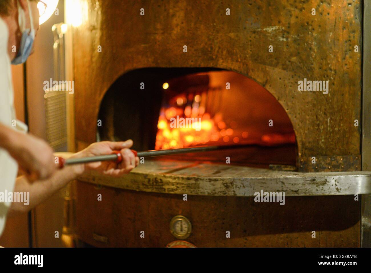 Italian chef preparing a traditional copper oven fueled by wood in ...
