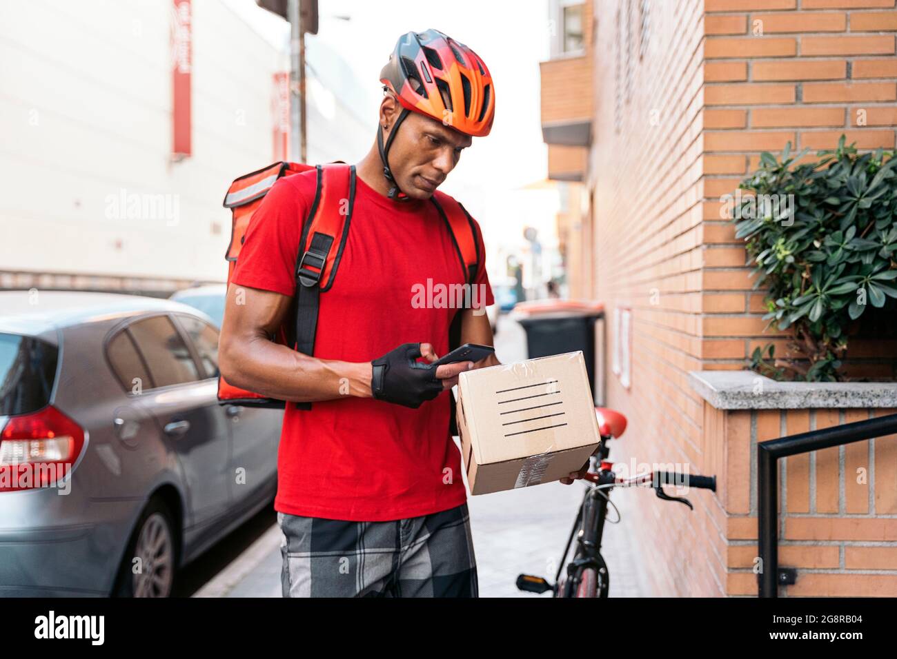 African messenger man preparing package for delivery in the destination ...