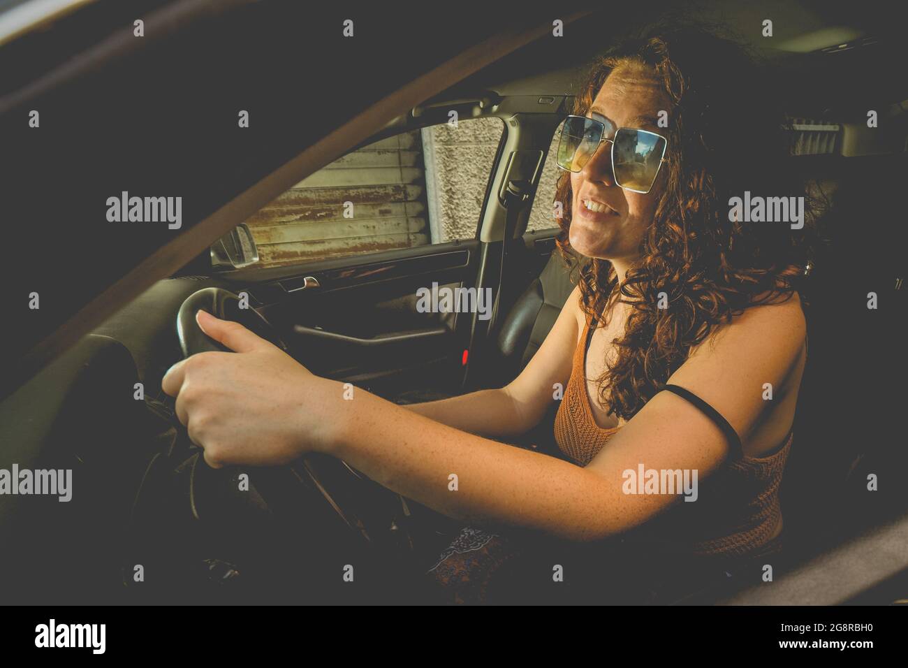 Attractive smiling Italian woman driving a car Stock Photo - Alamy