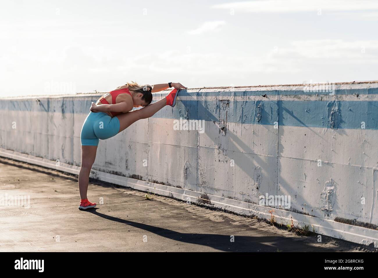 Flexible asian woman wearing sports clothes stretching after her ...