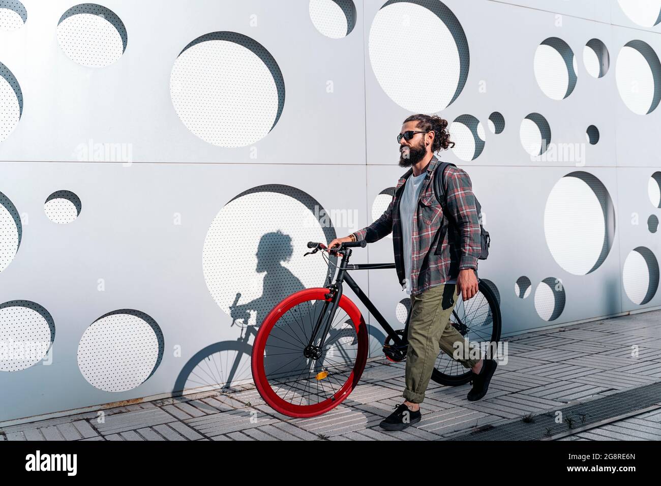 Confident man with long beard walking in the street with his cool bike Stock Photo - Alamy