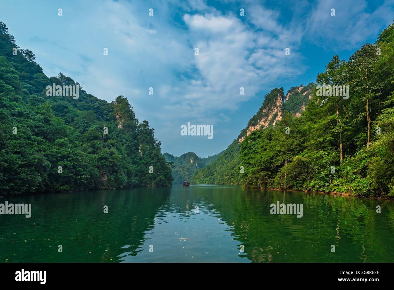 Tourist boat sailing among stunningly beautiful karst landscape ...