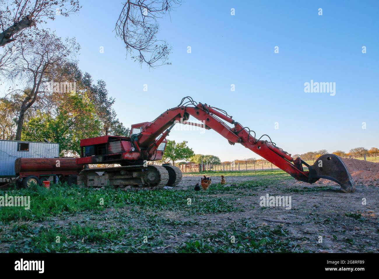 Red excavator in the field Stock Photo - Alamy