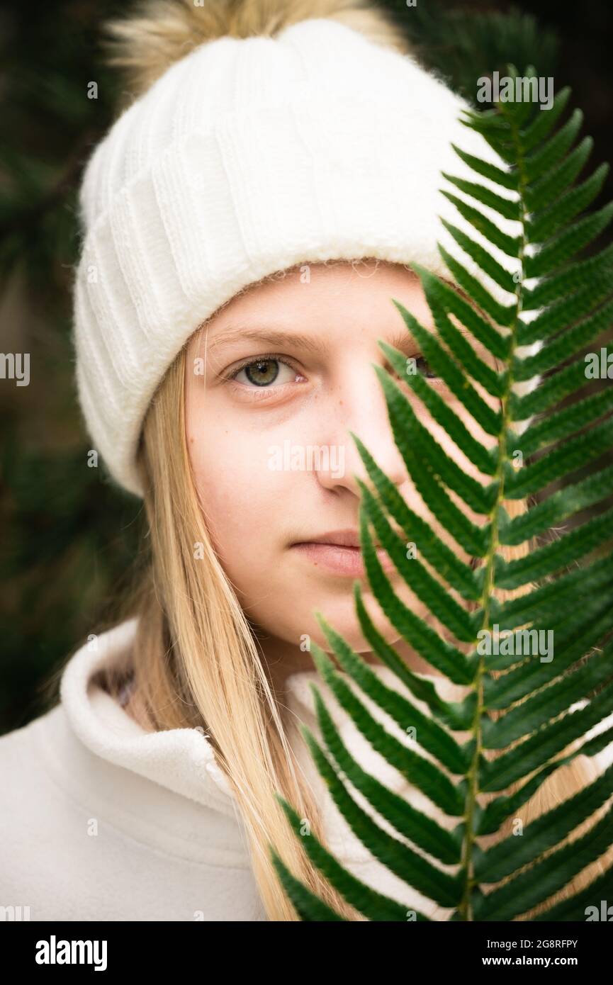 Young Girl Wearing Winter Hat Holding Green Fern in Front of Face Stock ...