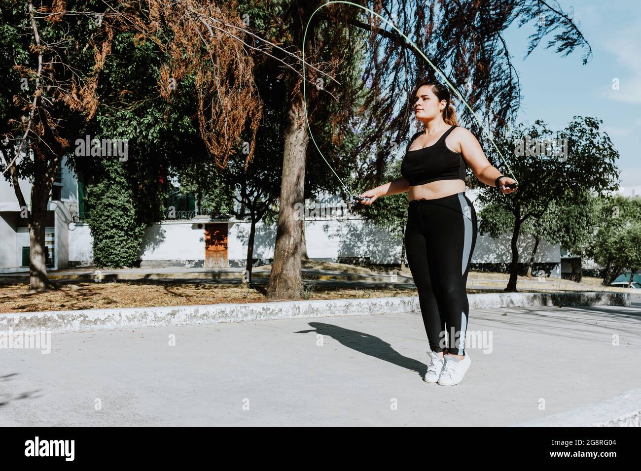 young Latin plus size woman jumping the rope in park in Mexico Stock ...