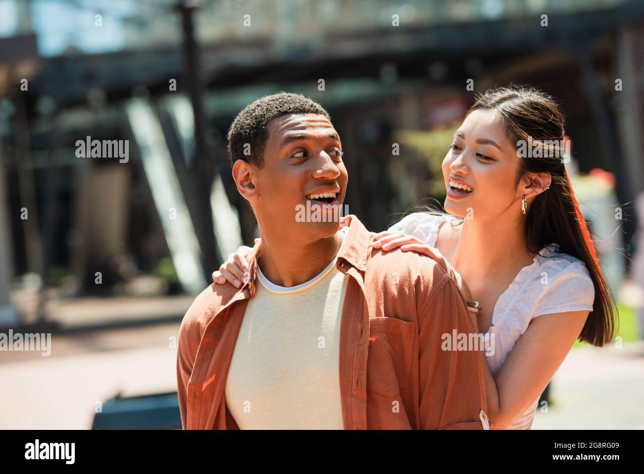 Man woman walking smiling hug street hi-res stock photography and ...