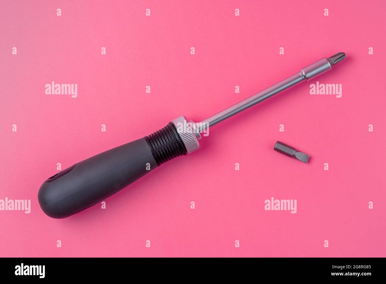 Black screwdriver with replaceable tip on the pink background Stock ...