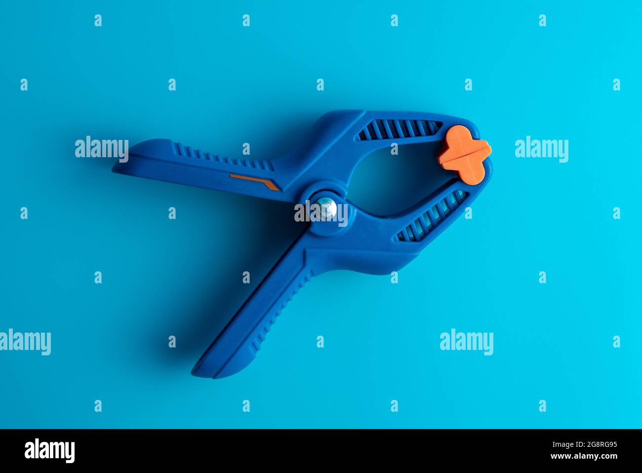 Isolated blue clamp tool on the blue background Stock Photo - Alamy