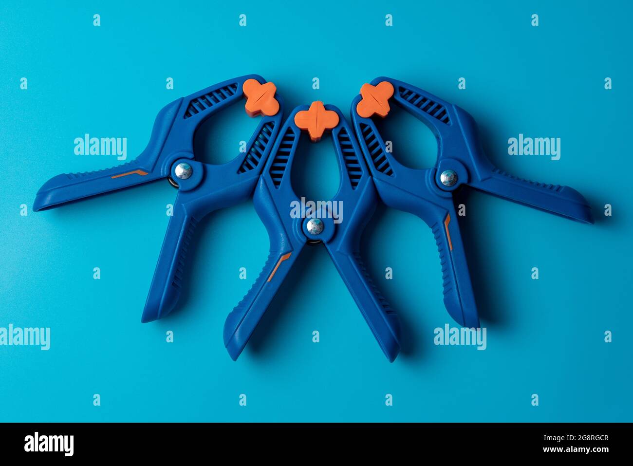 Isolated blue clamp tool on the blue background Stock Photo - Alamy