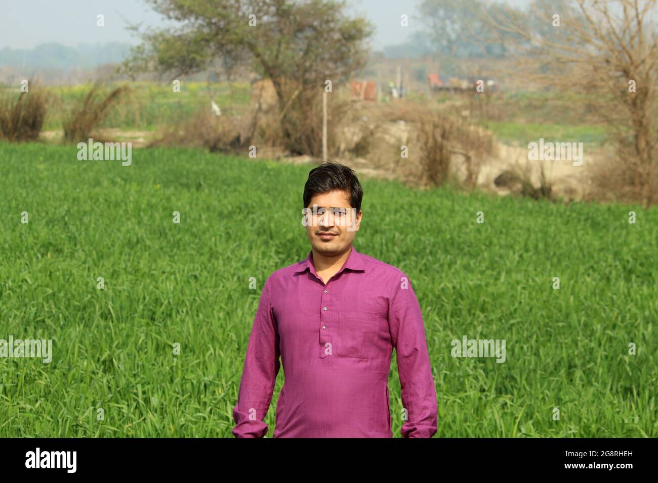 worry less ,indian farmer standing hand folded in his healthy wheat ...