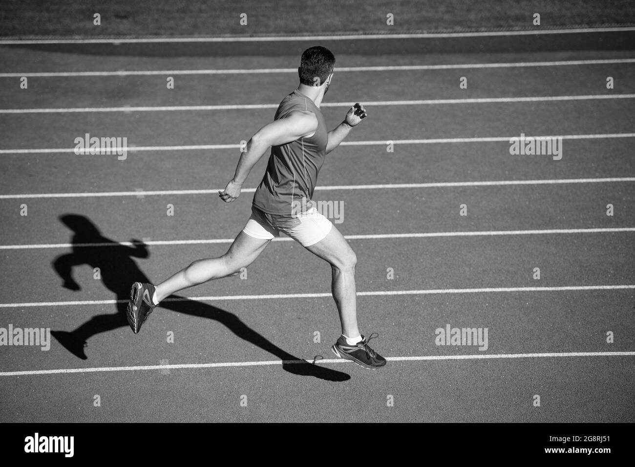 sportsman guy in sportswear run fast sprinting on running track ...