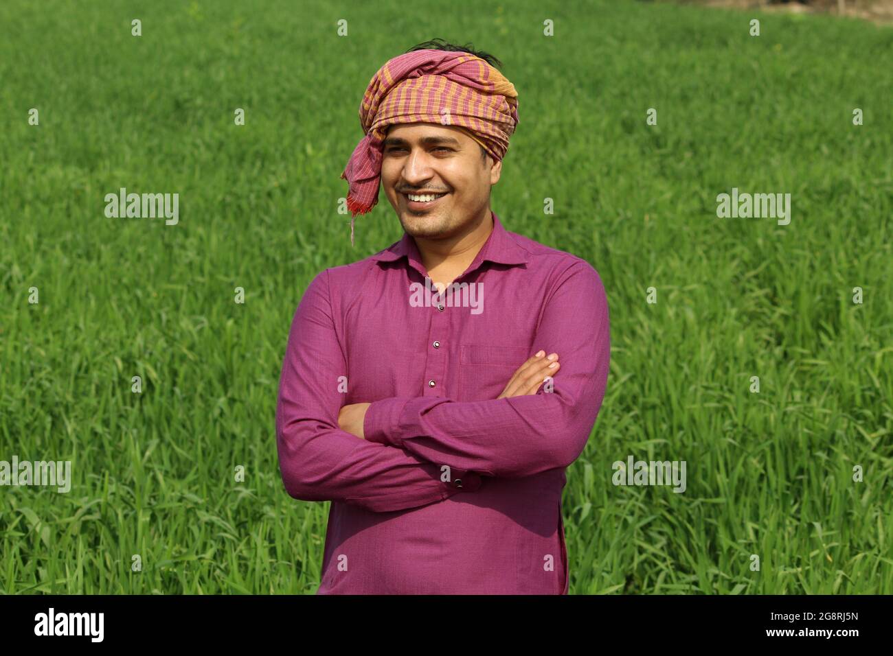 worry less ,indian farmer standing hand folded in his healthy wheat ...