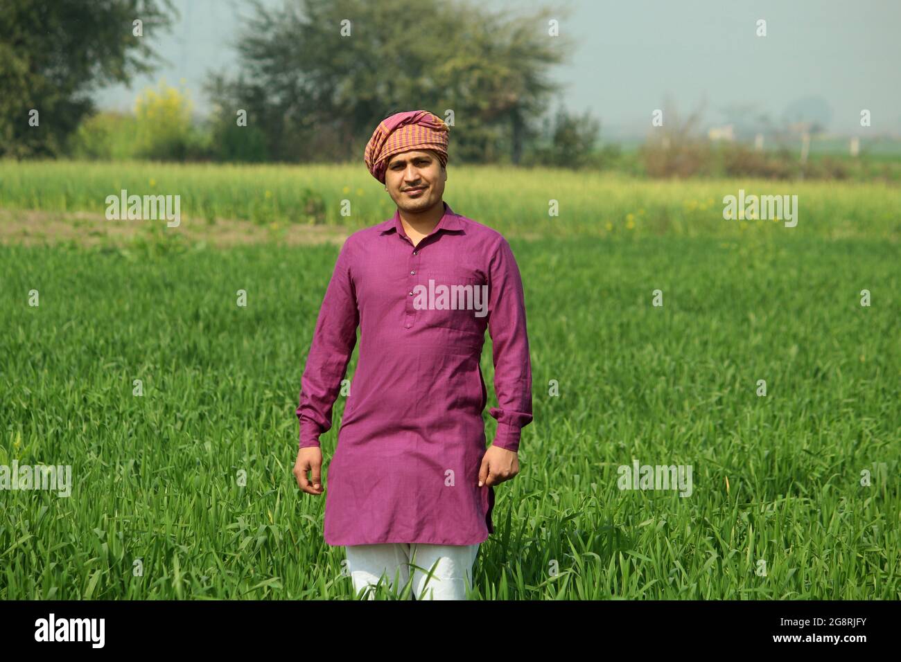 worry less ,indian farmer standing hand folded in his healthy wheat ...