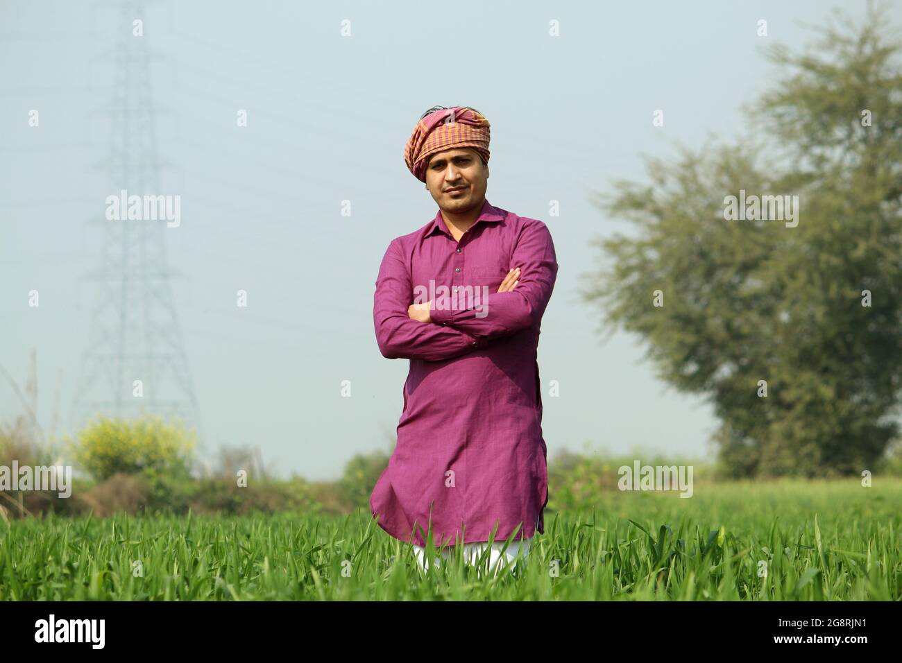 worry less ,indian farmer standing hand folded in his healthy wheat ...