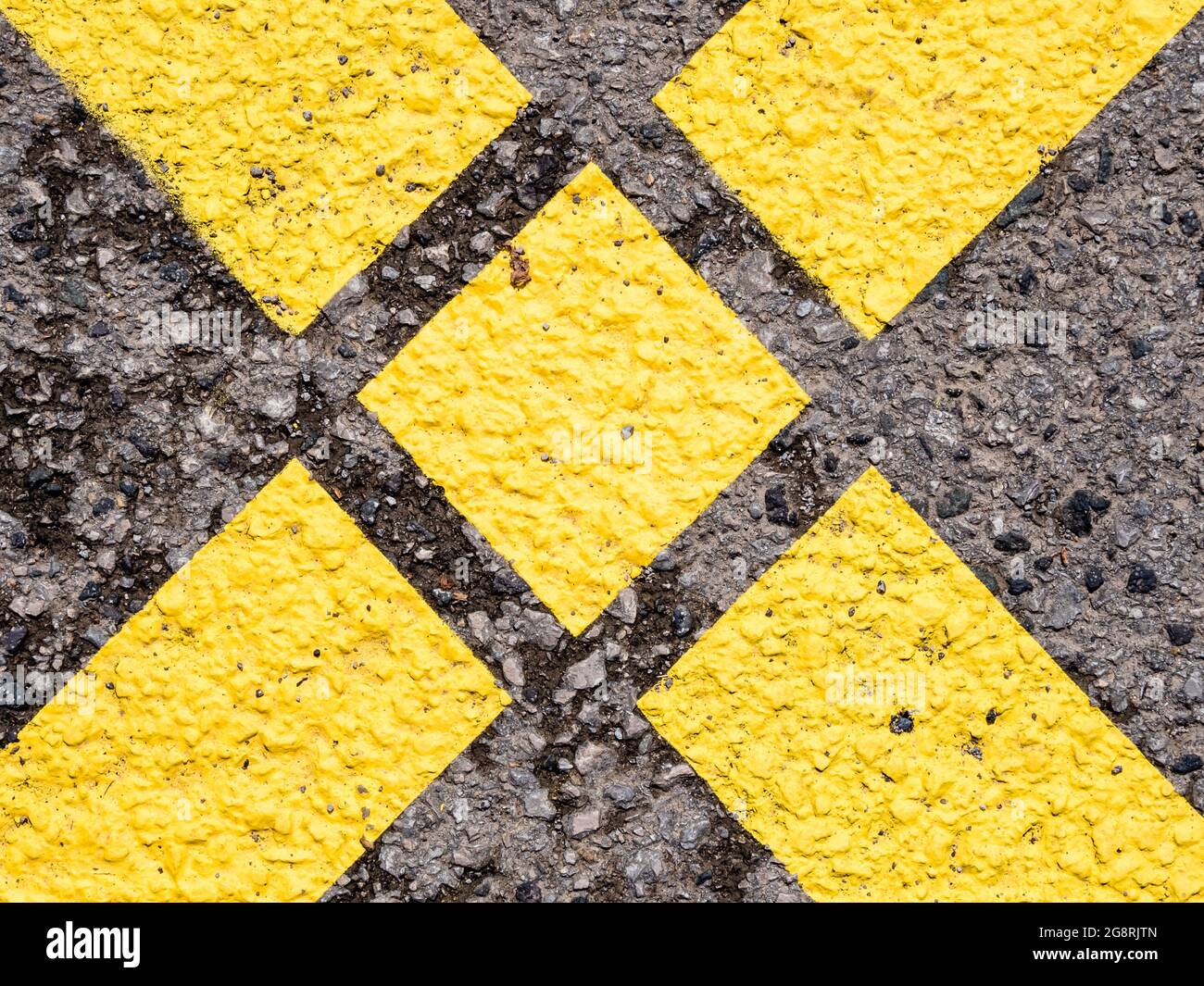 Yellow cross on an asphalt road Stock Photo - Alamy