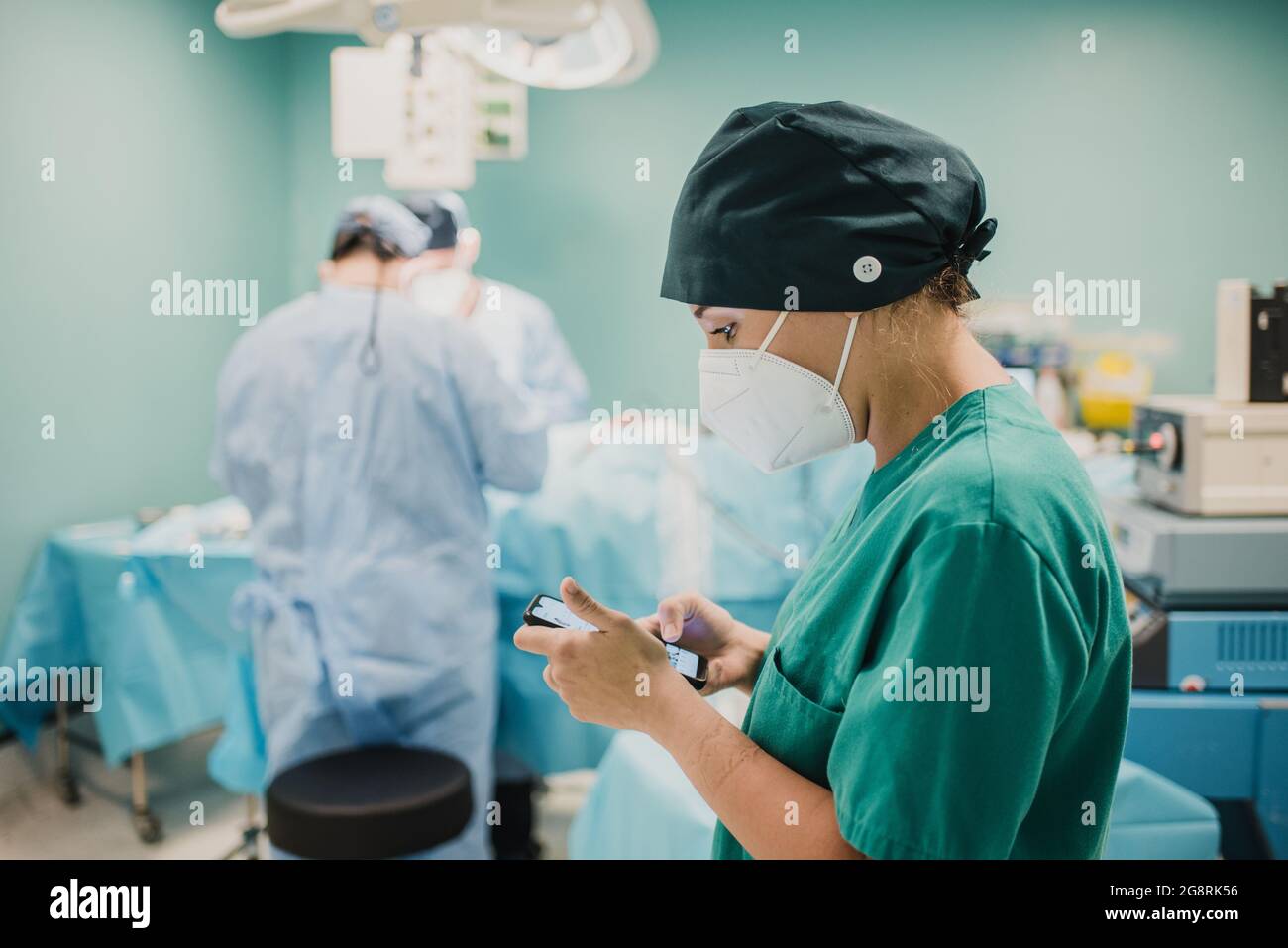 Female nurse using mobile phone inside operation room at modern ...