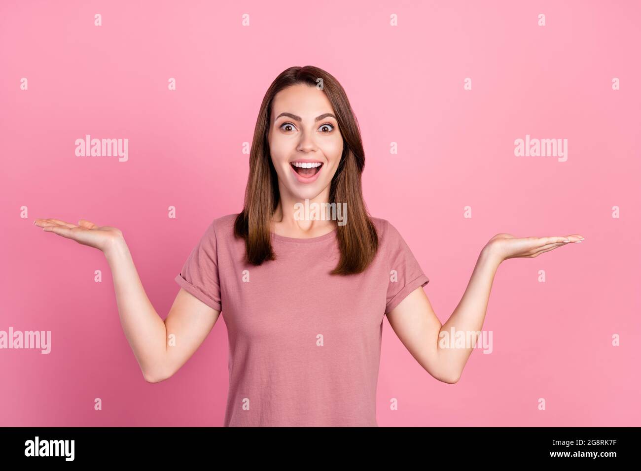 Photo of impressed brunette millennial lady hold empty space wear t ...