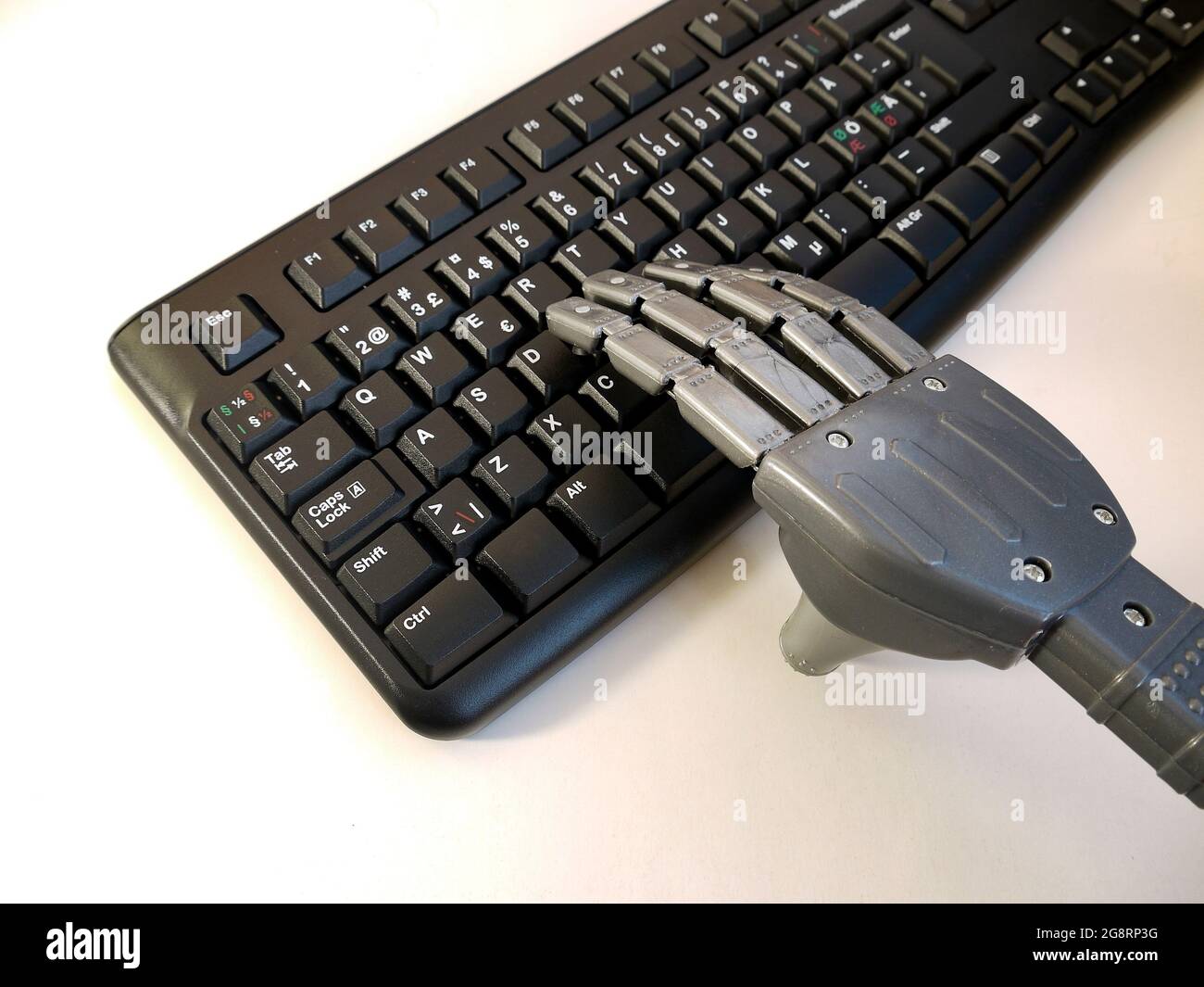 Hand of a robot working on a pc keyboard Stock Photo - Alamy