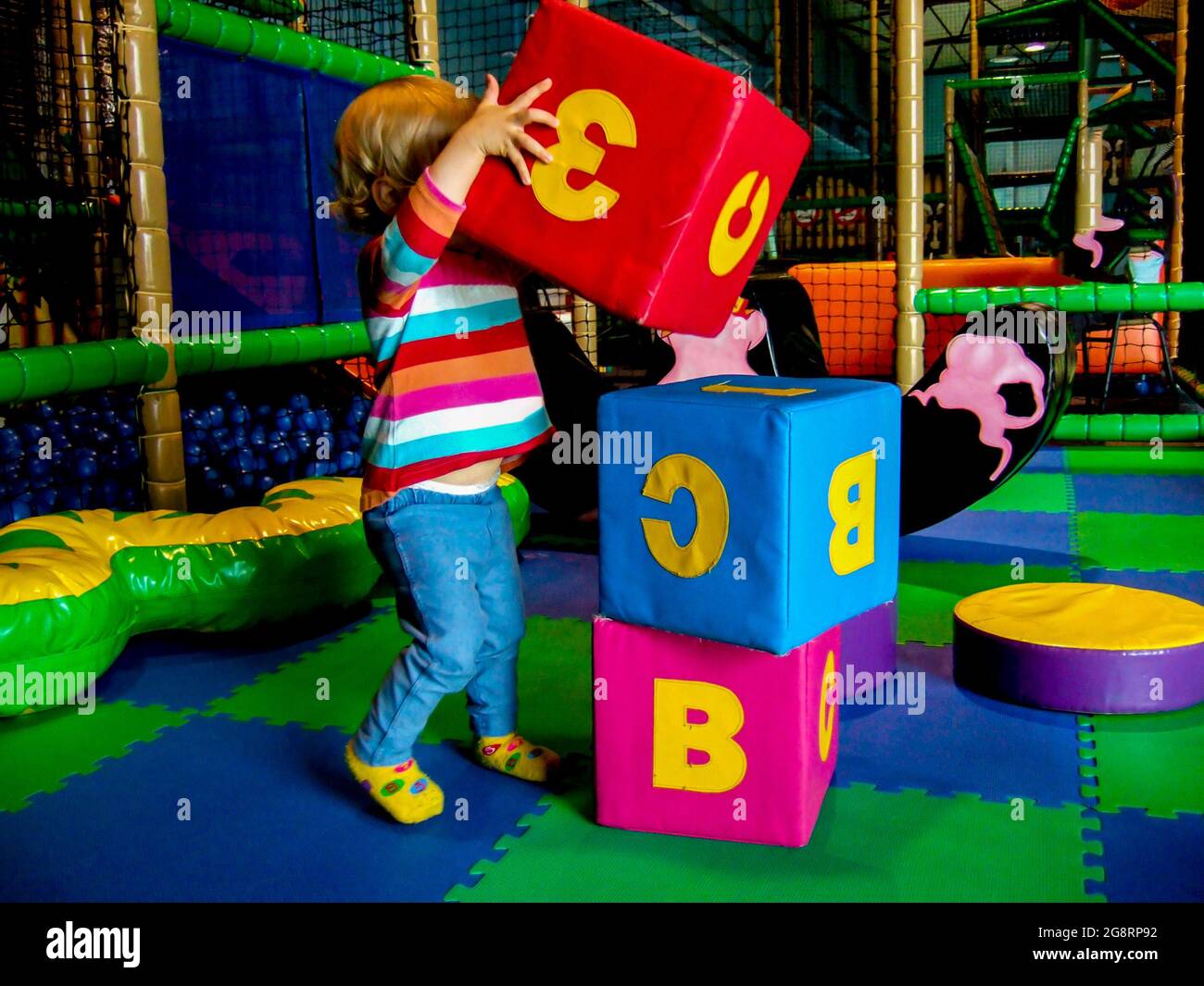 The child learns to build words from large cubes in the playroom ...