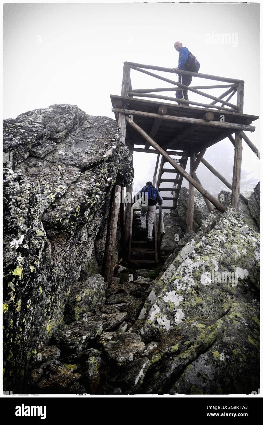 People climb a platform nestled between steep cliffs Stock Photo - Alamy