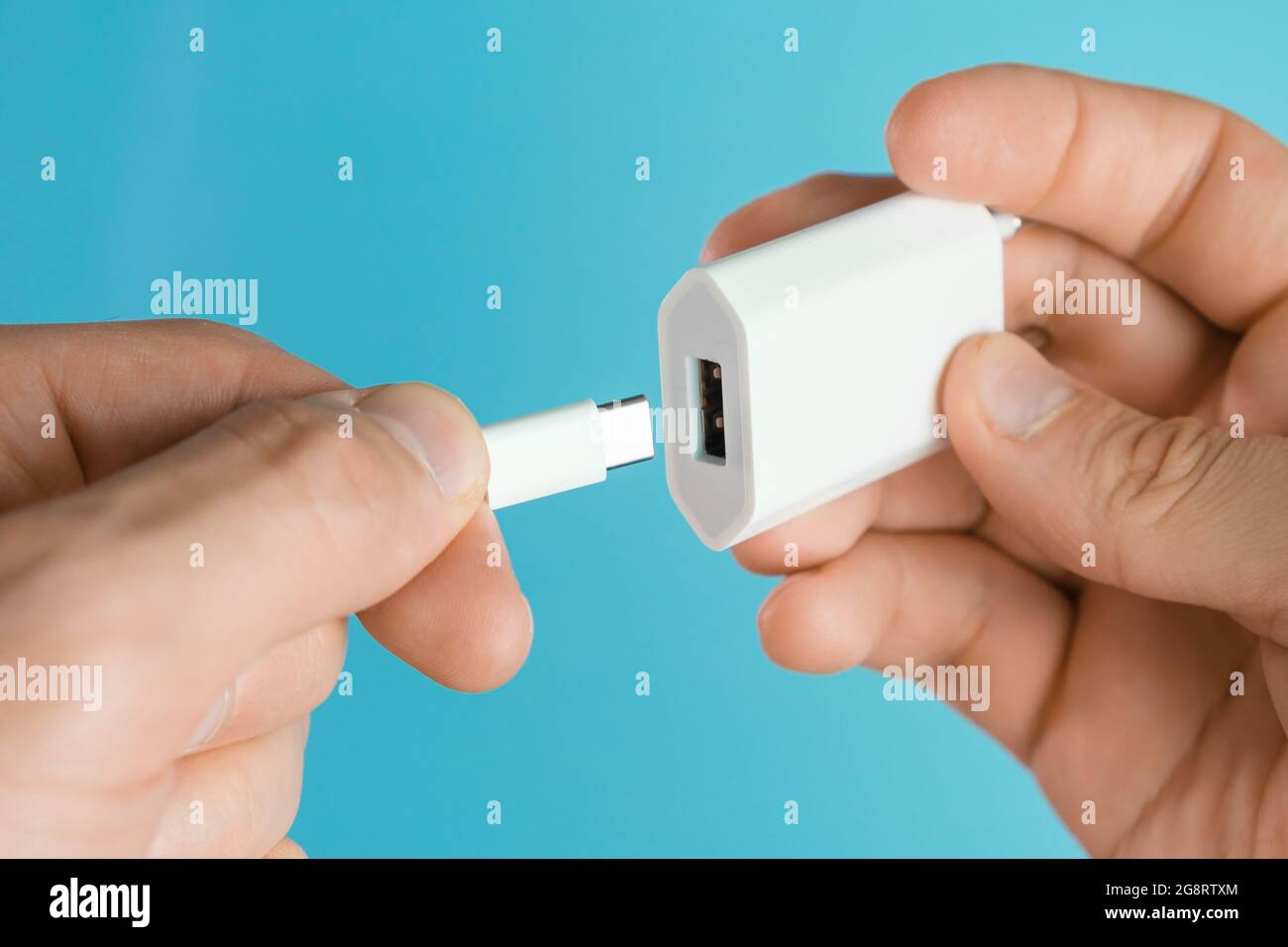 Usb type C cable and Usb type A adapter plug in mans hands on the blue ...