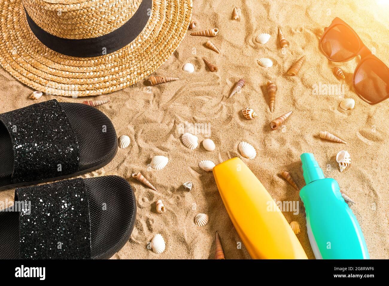 Summer beachwear, flip flops, hat, sunglasses and seashells on sand ...