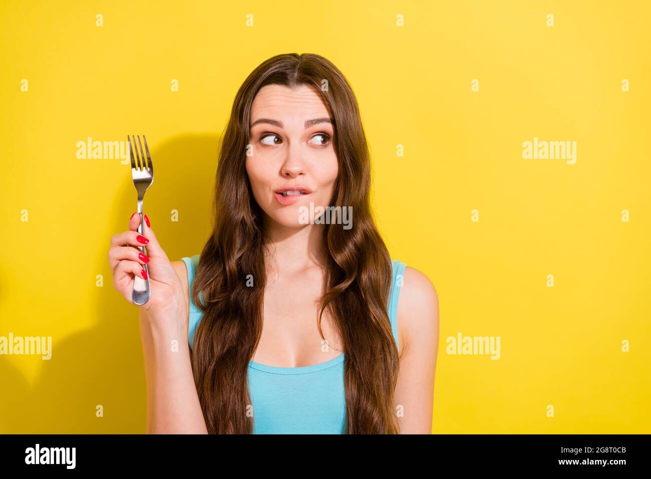 Portrait of attractive funky girlish hungry girl holding fork thinking ...