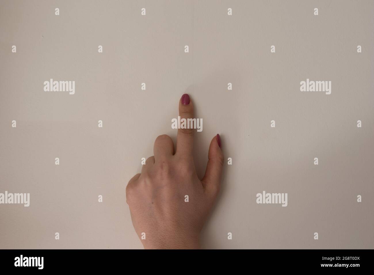 Woman hand with colored fingernails pointing at something or pressing a ...