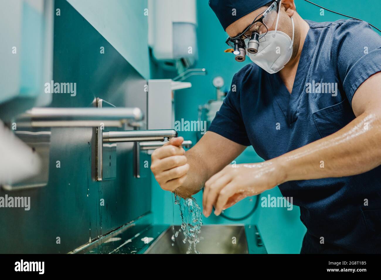 Medical surgeon cleaning hands before surgery inside hospital room ...