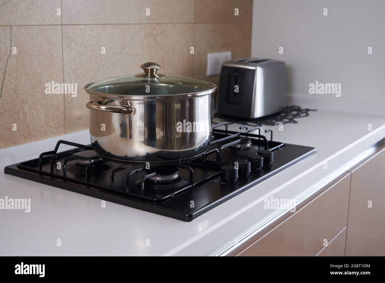 Pan on the gas stove in kitchen interior. Stainless steel pot. Cooking ...