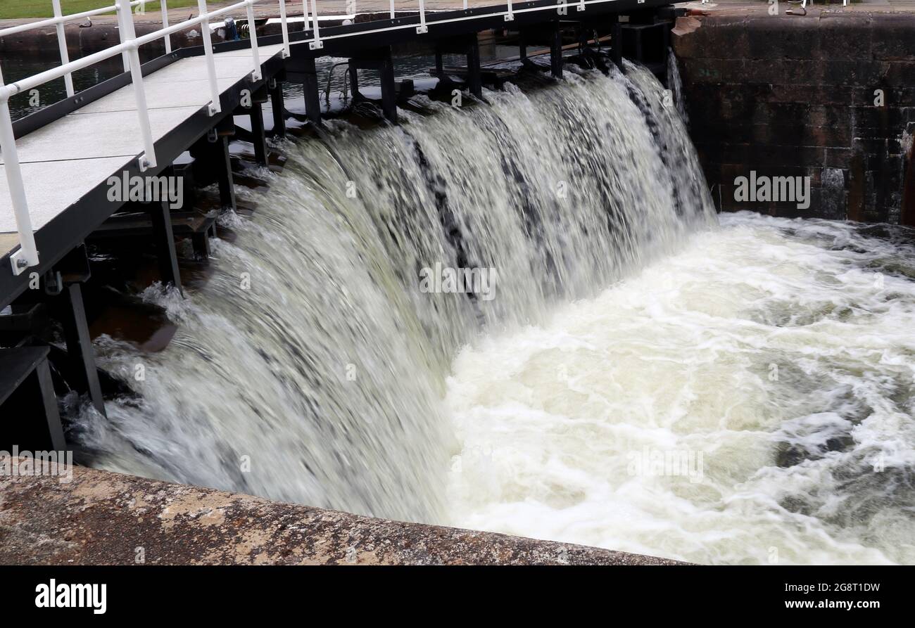 Canal lock gate and walkway with water raising water level in lock ...