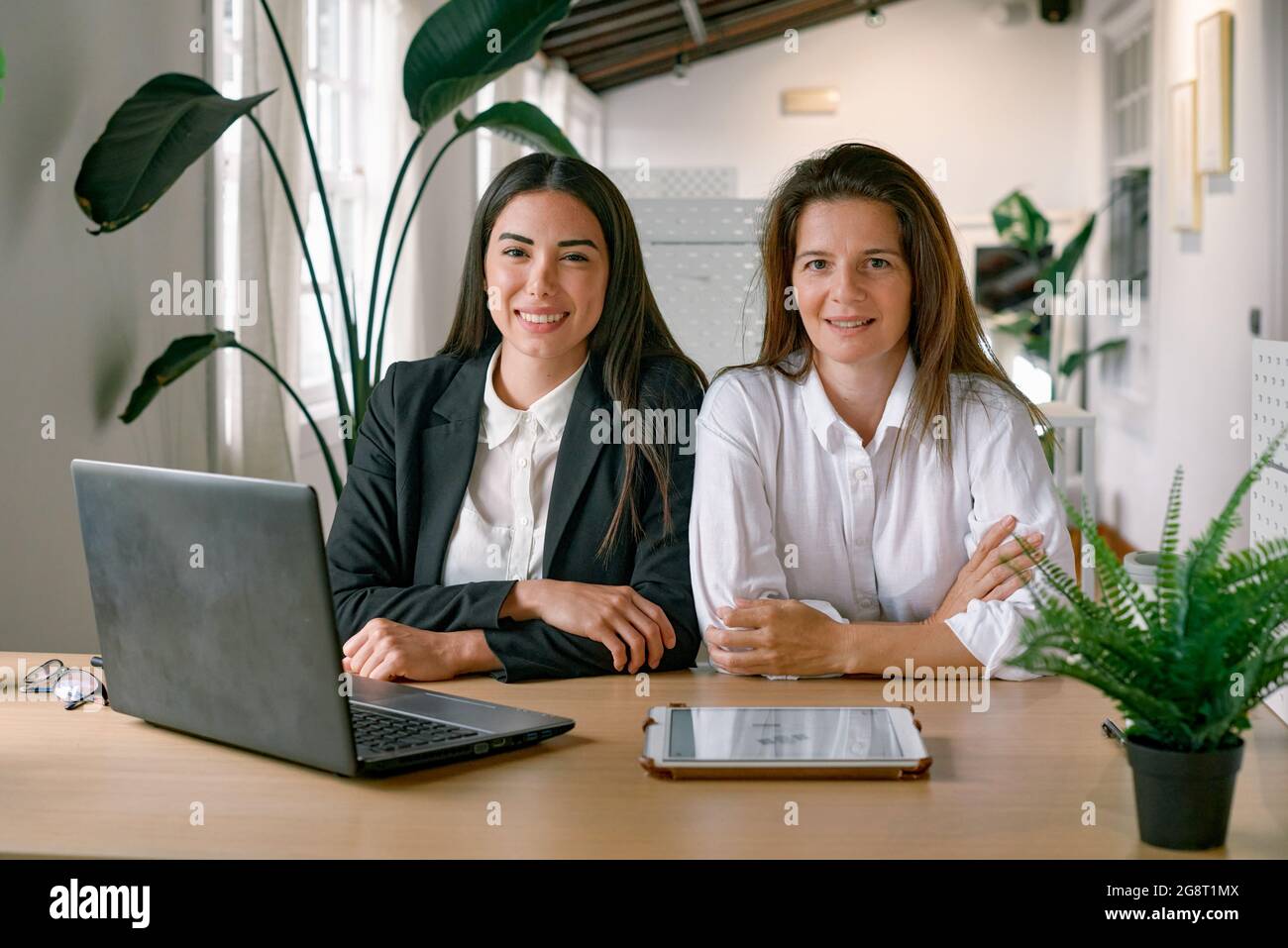 Friendly female managers looking at camera Stock Photo - Alamy