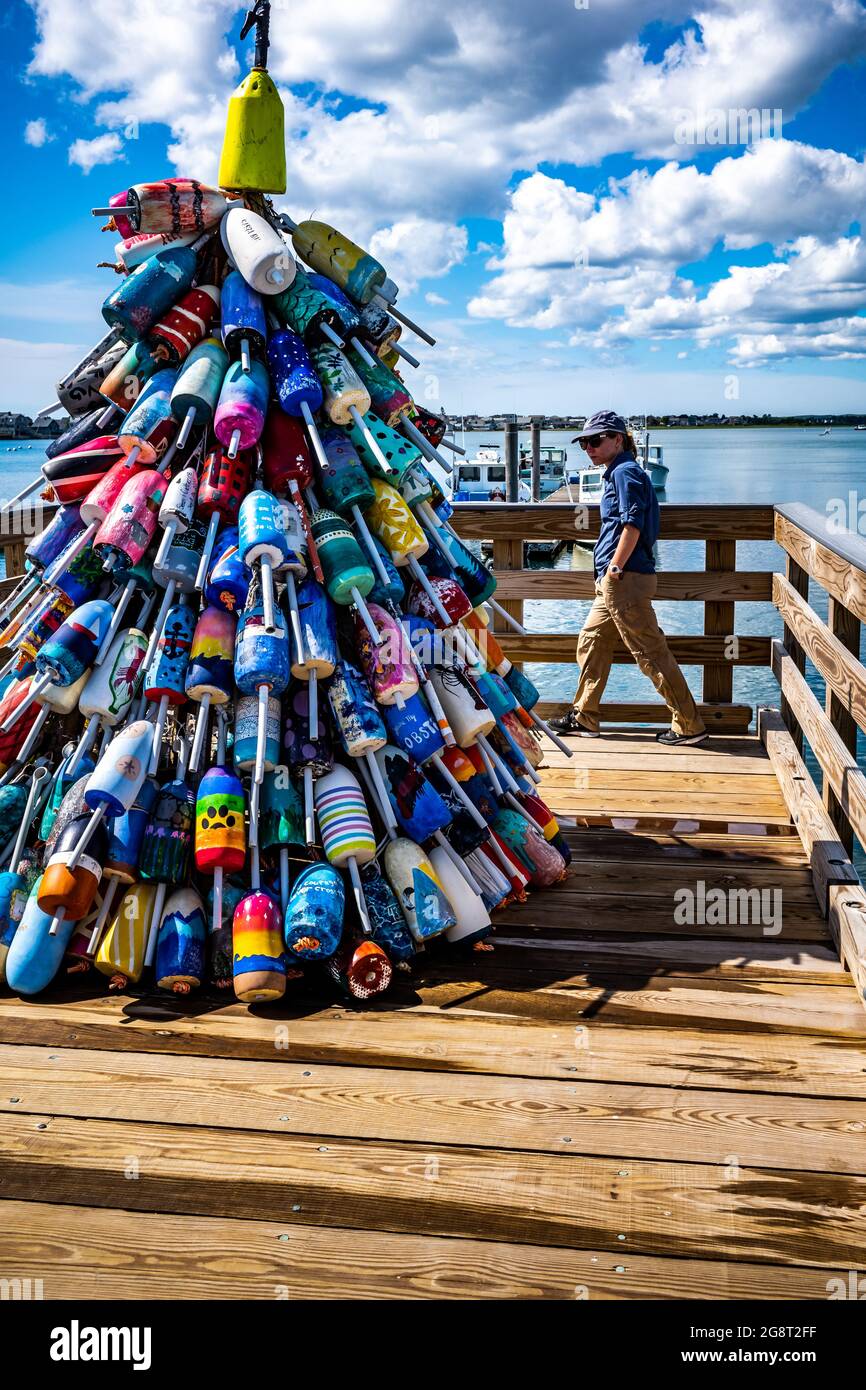 A woman looks over the pine tree shape tree that is made out of Lobster ...