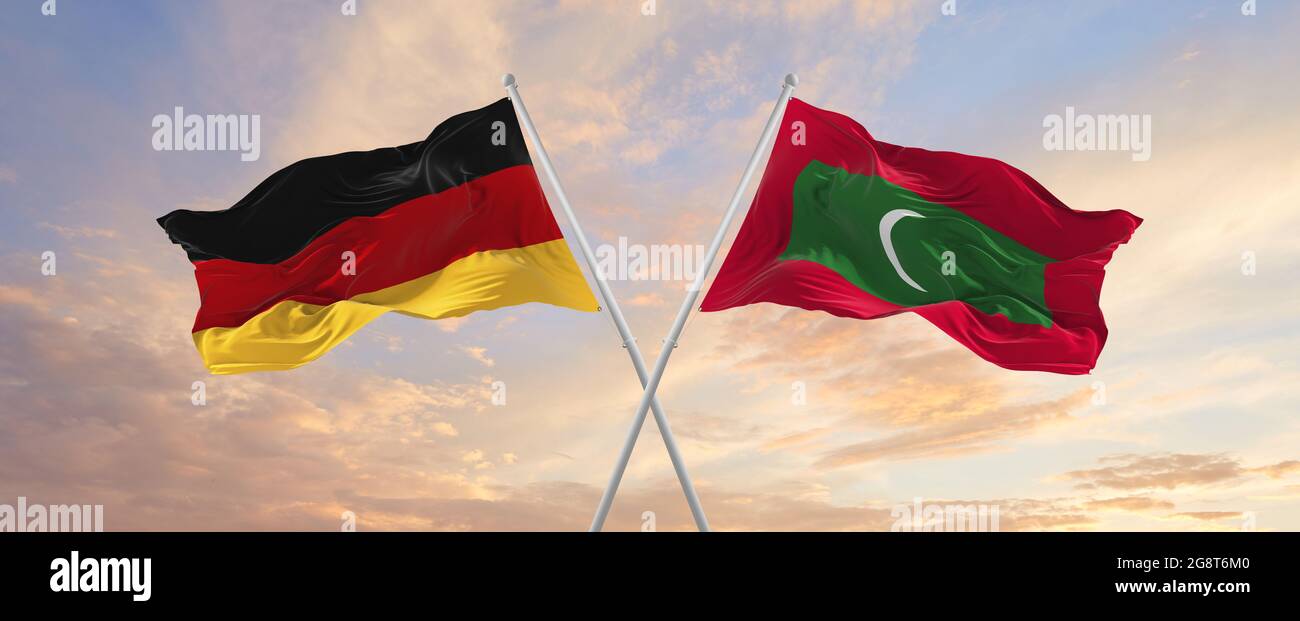 flags of Germany and Maldives waving in the wind on flagpoles against ...