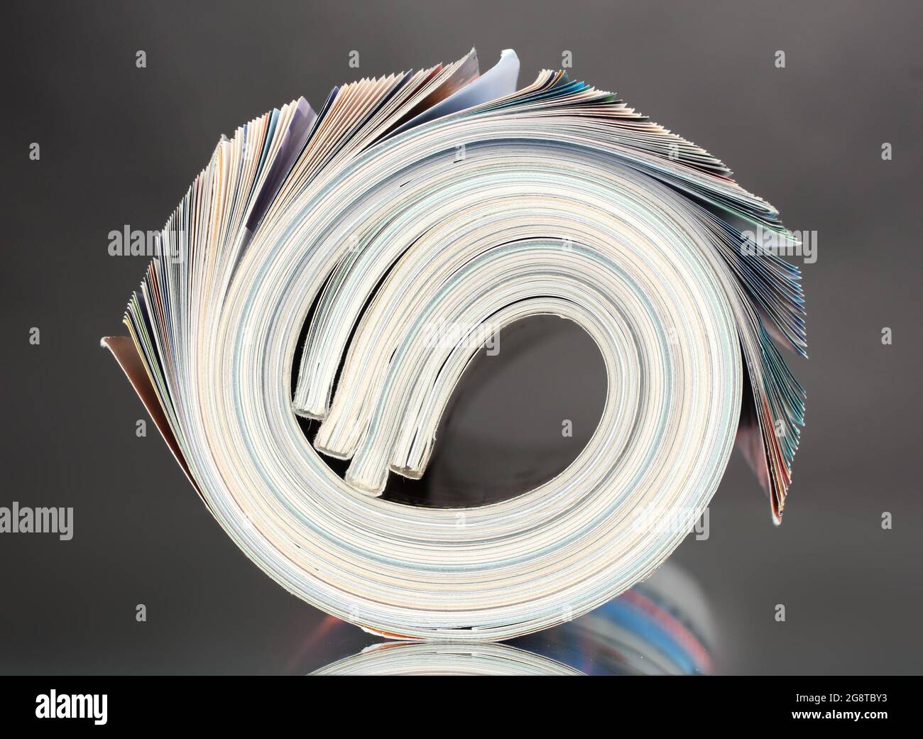 Rolled up magazines on gray background Stock Photo - Alamy