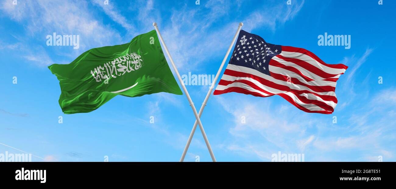 flags of USA and Saudi Arabia waving in the wind on flagpoles against ...