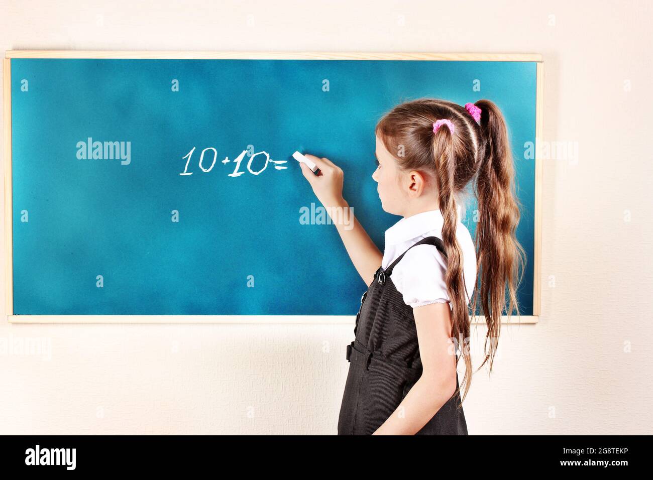 beautiful little girl writing on classroom board Stock Photo - Alamy