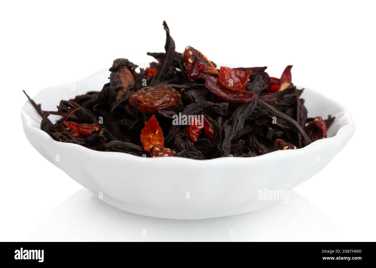 Black dry fruit tea leaves in plate isolated on white Stock Photo - Alamy
