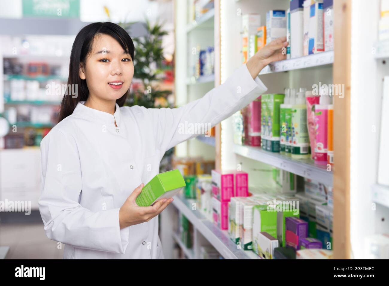 Chinese female pharmacist standing in pharmacy Stock Photo - Alamy