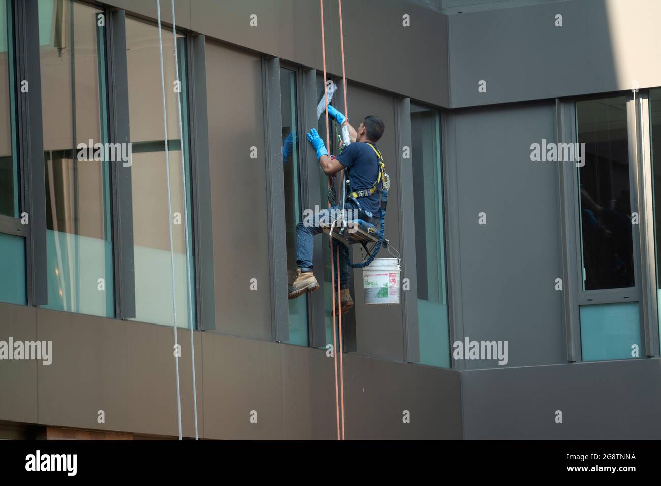 A man washing the windows of an apartment building in Tribeca, a ...