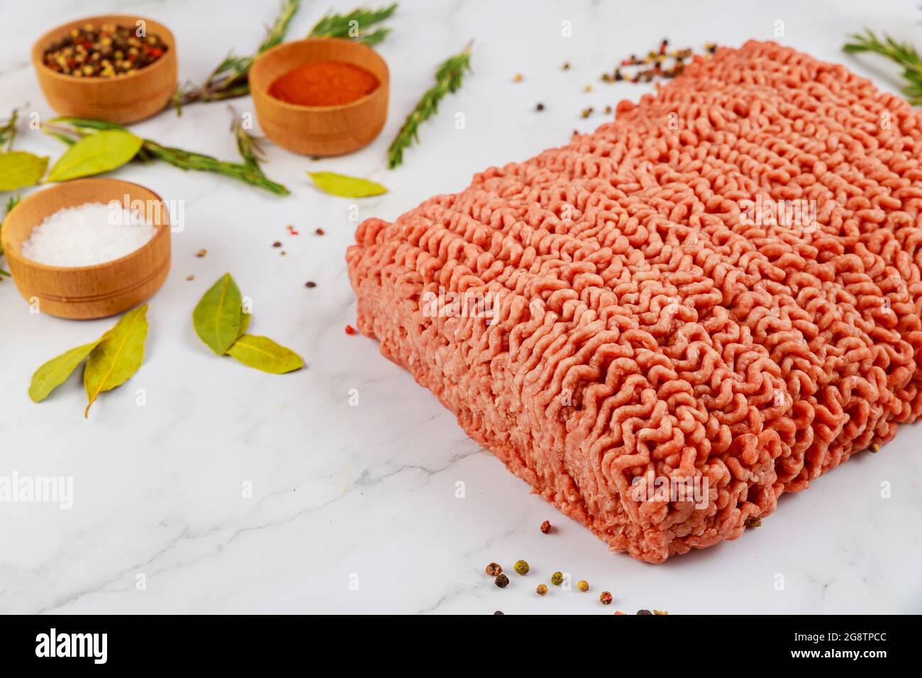Raw ground beef with spices and rosemary on white background Stock ...