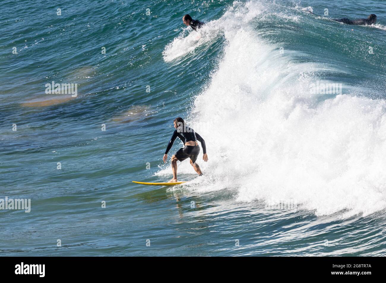 Australian male surfer riding the waves off the coast of Avalon Beach ...