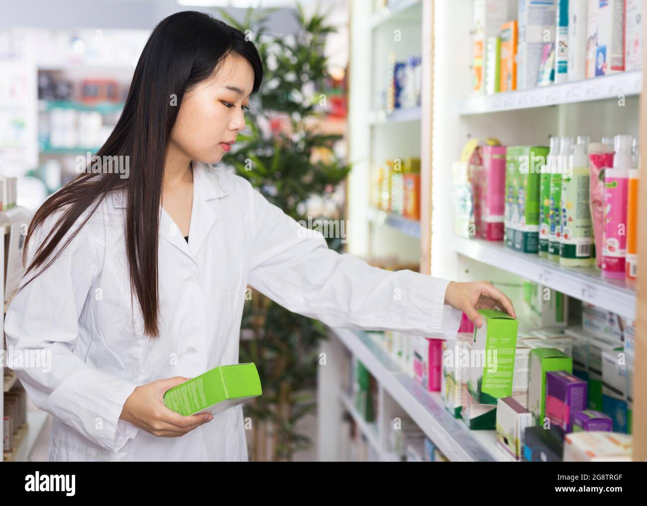Chinese female pharmacist standing in pharmacy Stock Photo - Alamy