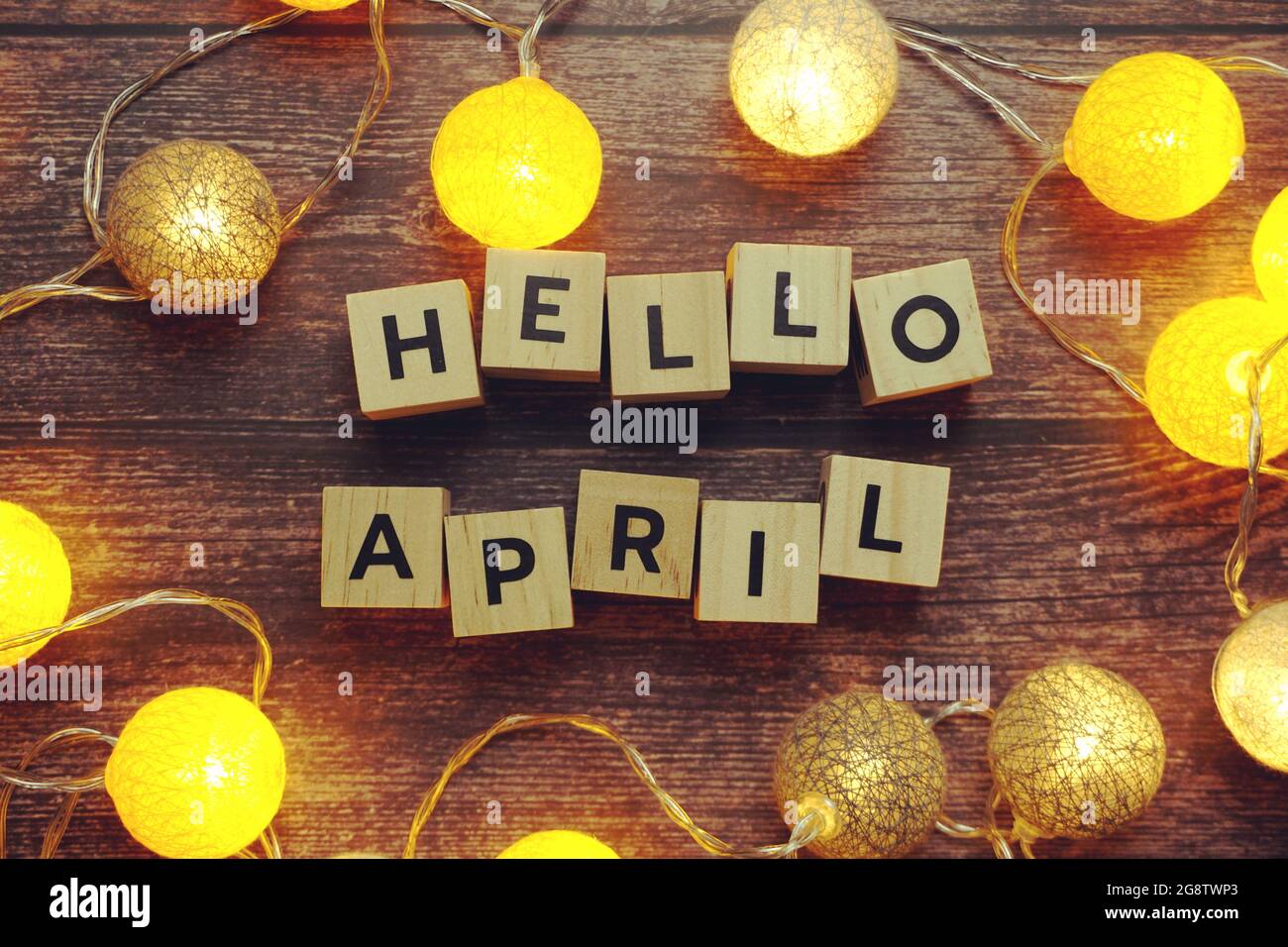 Hello April alphabet letter with LED cotton balls on wooden background ...