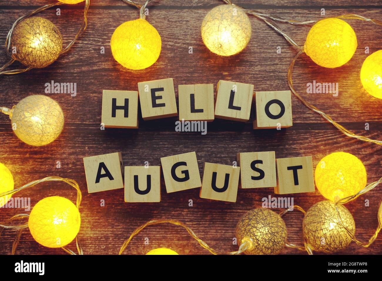 Hello August alphabet letter with LED cotton balls on wooden background ...