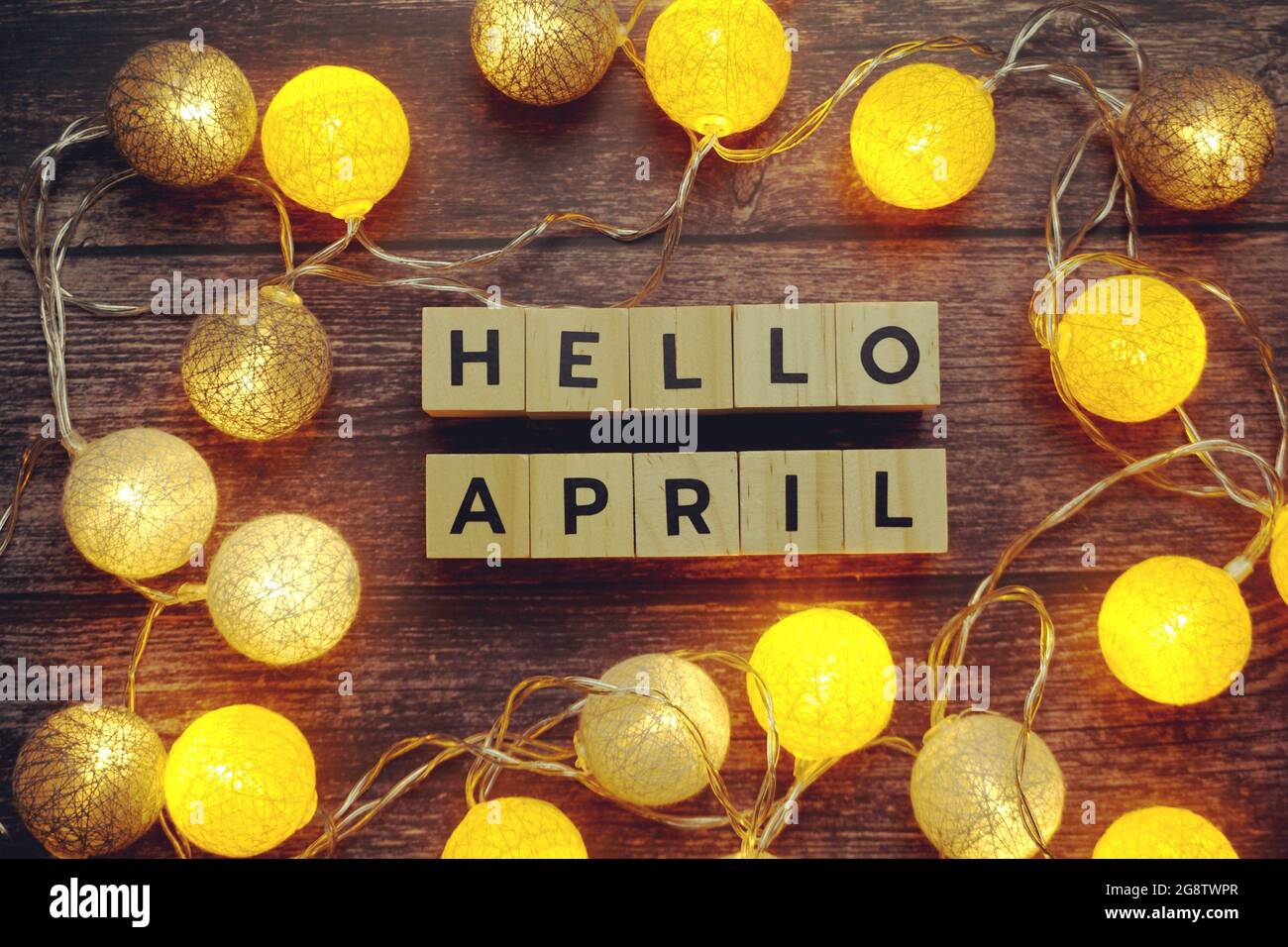 Hello April alphabet letter with LED cotton balls on wooden background ...