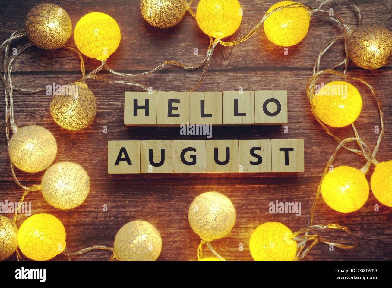 Hello August alphabet letter with LED cotton balls on wooden background ...