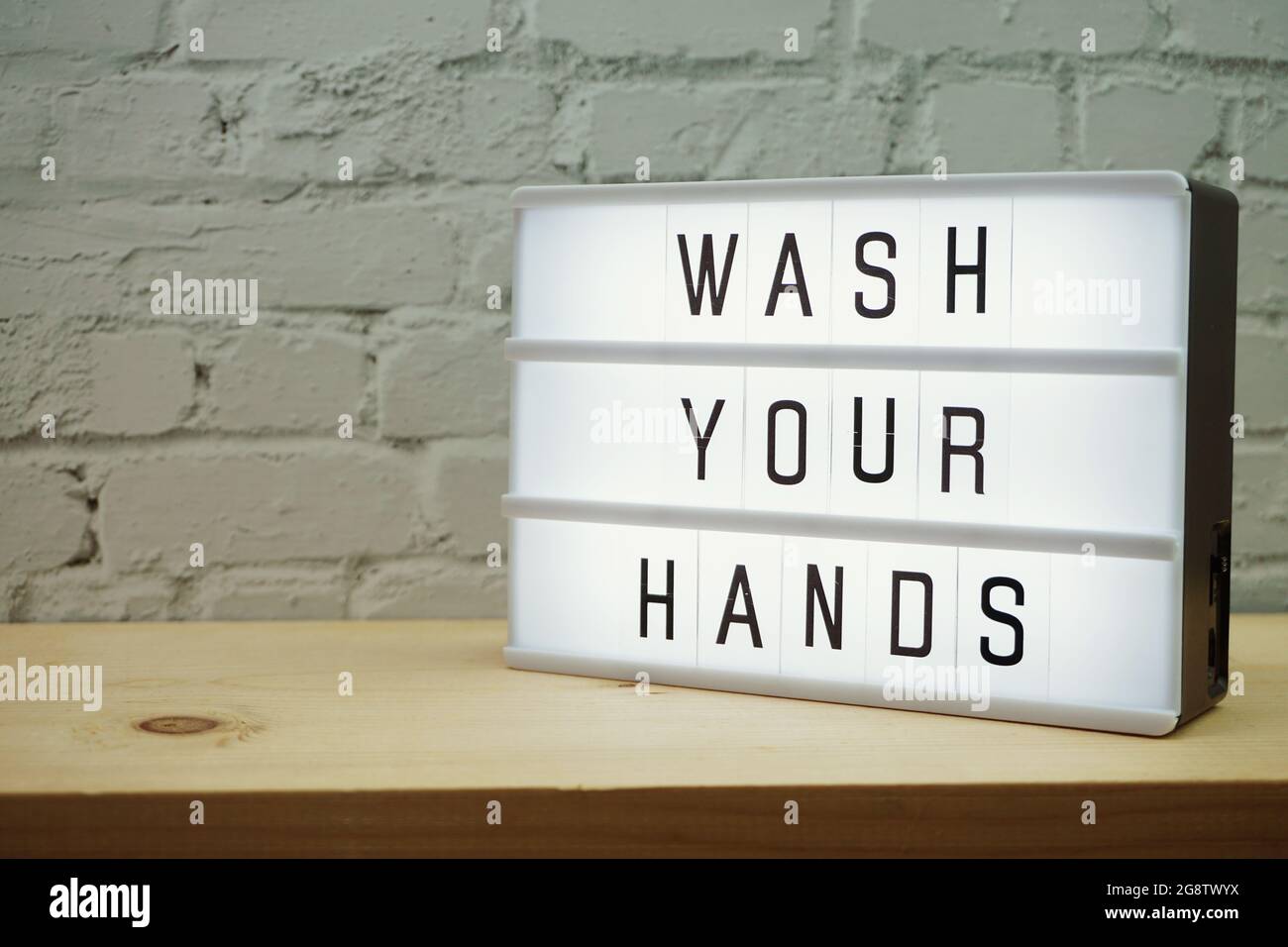 Wash Your Hands word in light box with space coy on white brick and ...