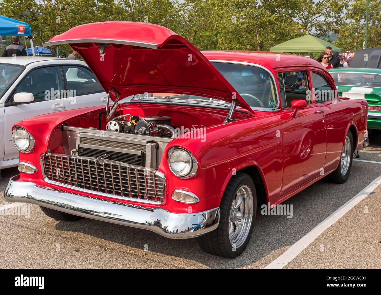 A vintage red coupe automobile from the 1950s with it's hood open at a ...