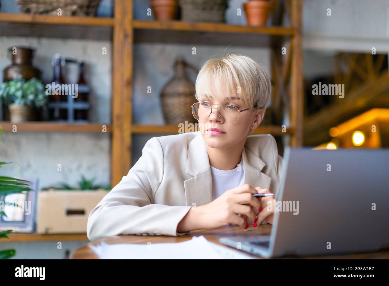 Concentrated woman works papers laptop hi-res stock photography and ...